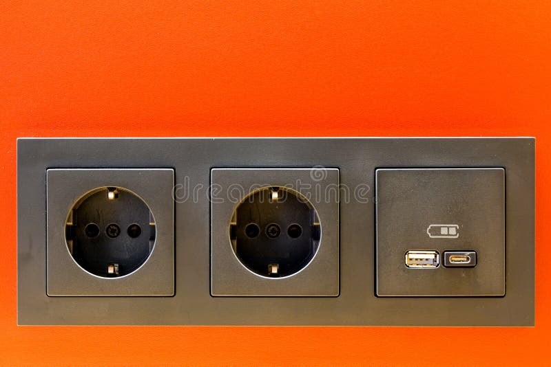 A Black 220V, USB and USB C Socket Block is Built into the Orange Wall ...