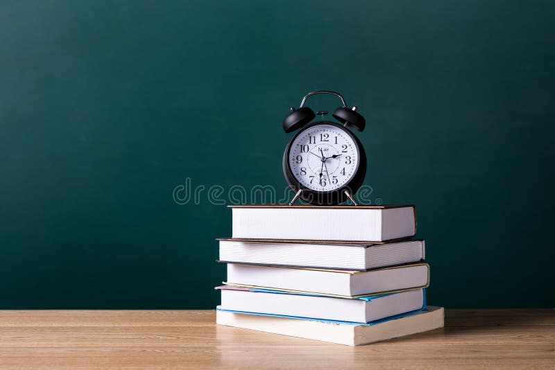 Black Vintage Alarm Clock on the Stack of Books Stock Photo - Image of ...