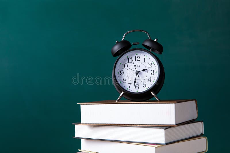 Black Vintage Alarm Clock on the Stack of Books Stock Image - Image of ...
