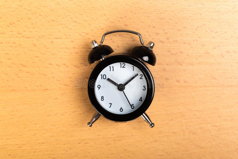 Black Vintage Alarm Clock on a Wooden Table, Top View. Concept of Time ...