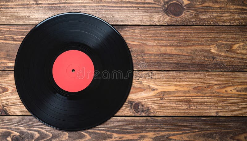 Black Vinyl Record with Red Label on Brown Wooden Surface Stock ...