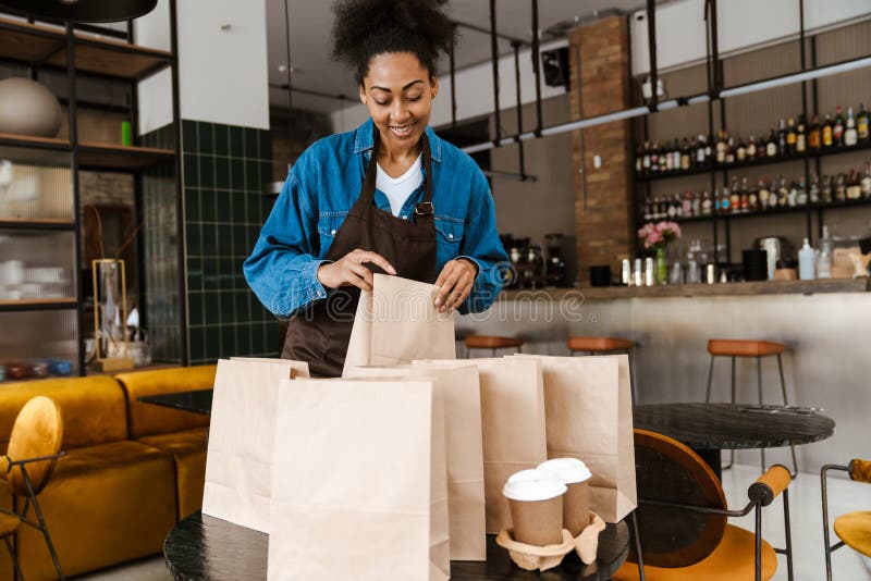 Black Waitress in Apron Packing Orders while Working at Cafe Stock ...