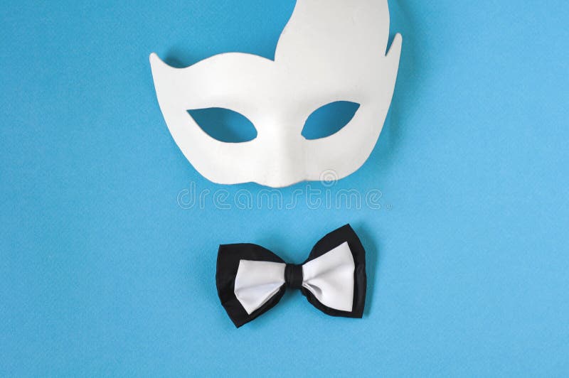 A Black and White Bow Tie and a White Carnival Mask on a Pastel Blue ...