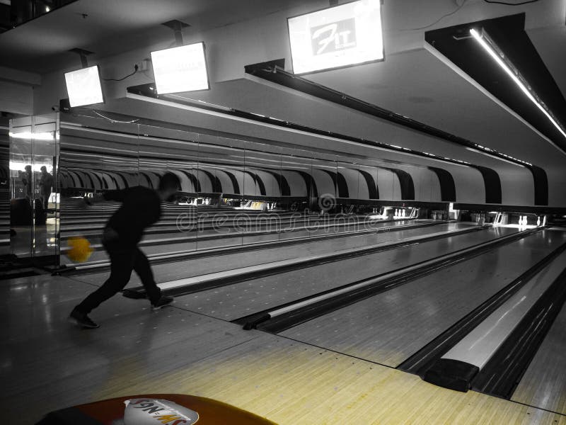 A Black and White Image of a Boy Playing Bowling Inside a Mall ...