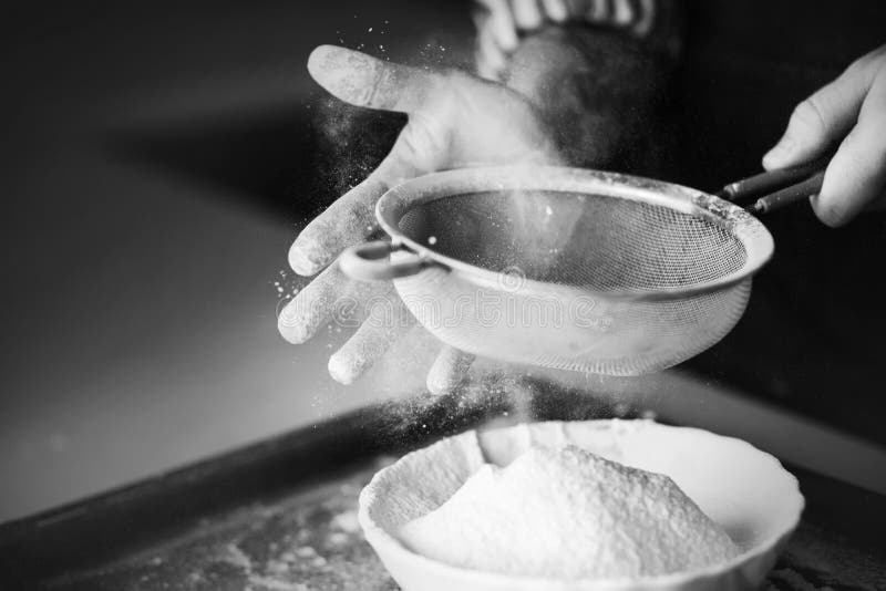 A Black-white Image of a Chef Using His Hand To Sift Flour through a ...