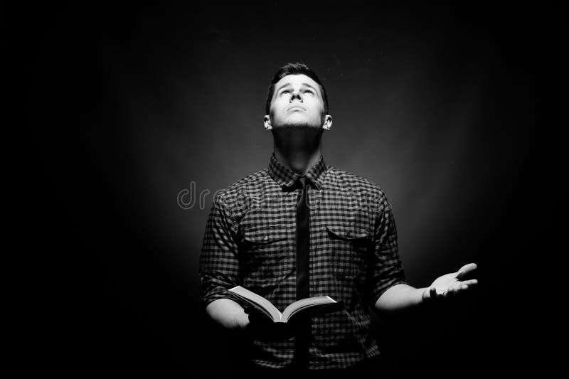Black and White Image of a Man Looking Up with a Book in One Hand and a ...