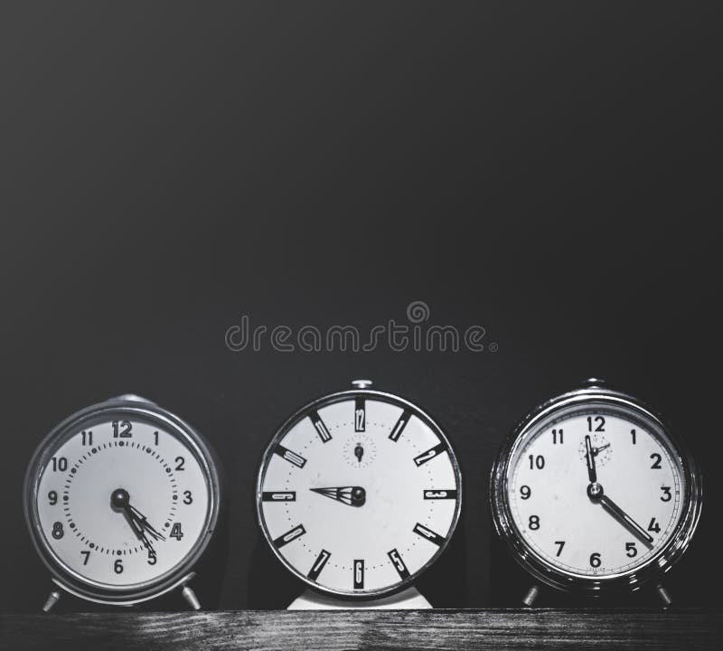 A Grayscale Shot of Three Old Fashioned Circular Analogue Clocks on a ...