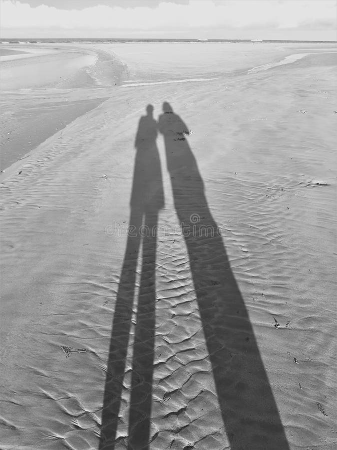 Black and White Image of Two Long Shadows of People on the Beach Stock ...