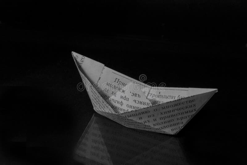 Black and White Paper Boat from an Old Newspaper on a Black Background ...