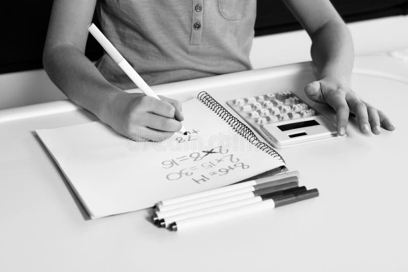 Black and White Photo of Child Doing Maths Homework Using Calculator ...