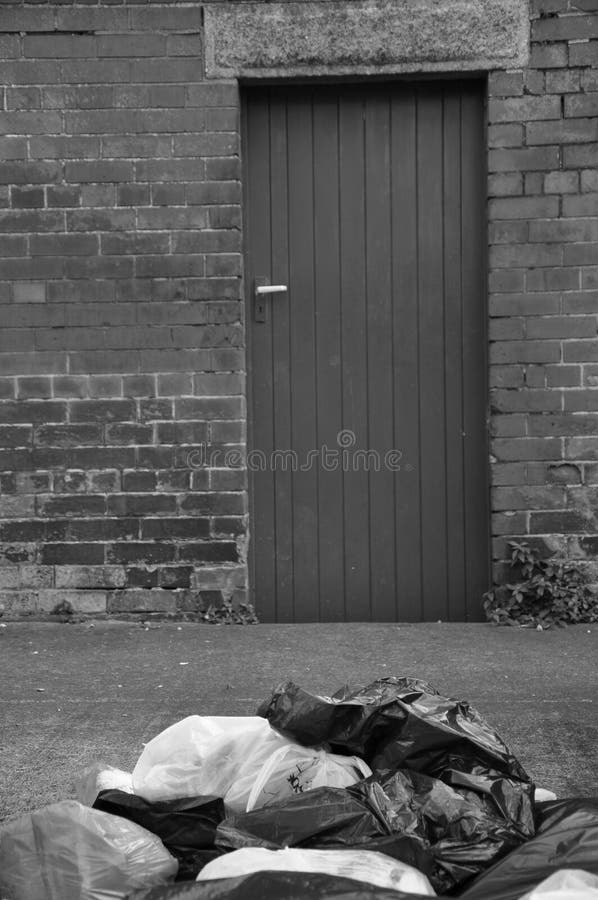 Black and White Rubbish Dumped Against Brick Wall Stock Photo - Image ...