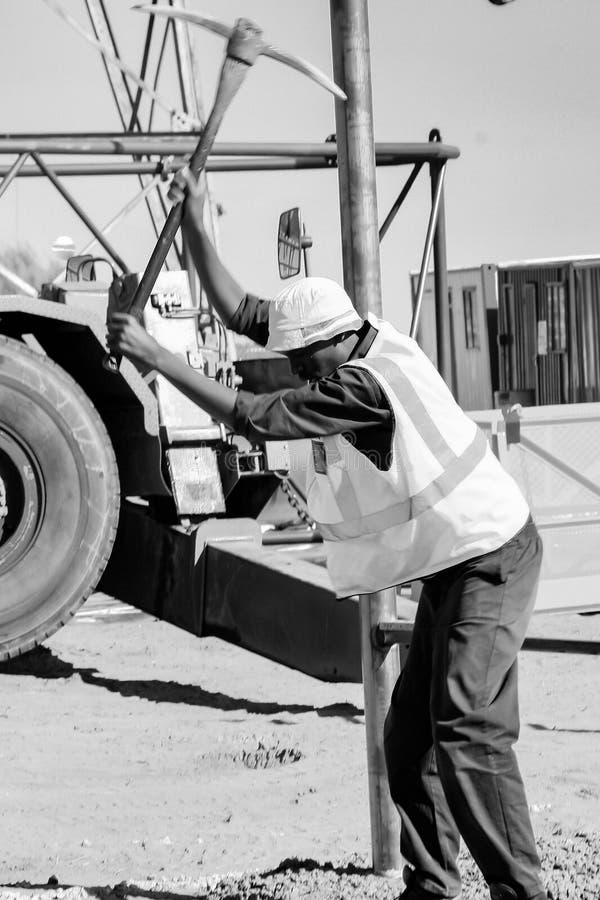 Black and White Shot of a Construction Worker Using a Pickaxe at a ...