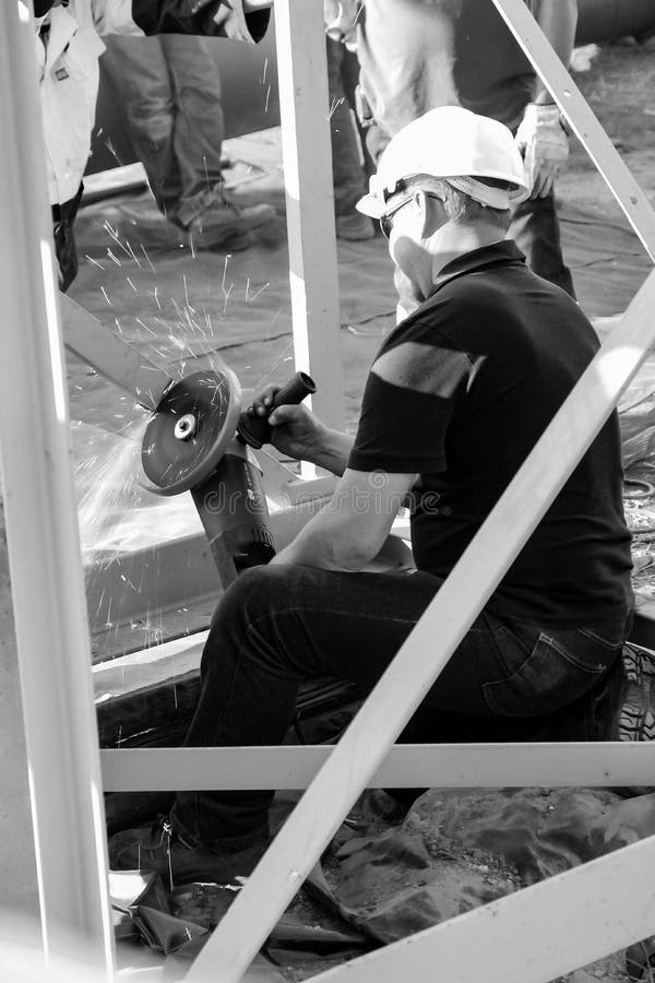 Black and White Shot of a Construction Worker Using a Power Tool with ...