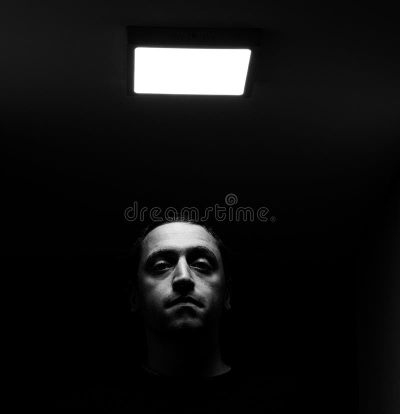 Black-and-white Shot of a Man Standing Under the Square Light in Dark ...