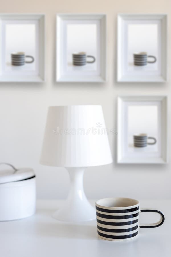 Black and White Striped Mug, a Lamp with a Shade and a Cookie Box on a ...