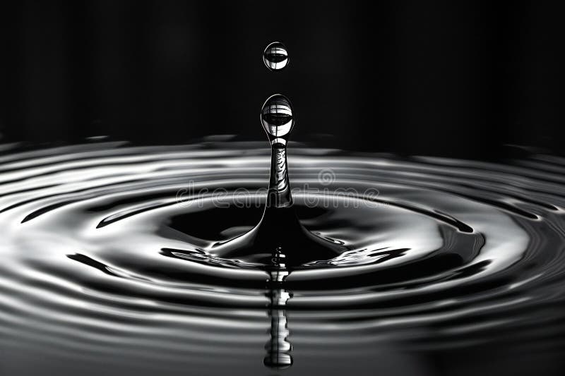 A Black and White Water Drop Ripples Across the Surface of an All-black ...