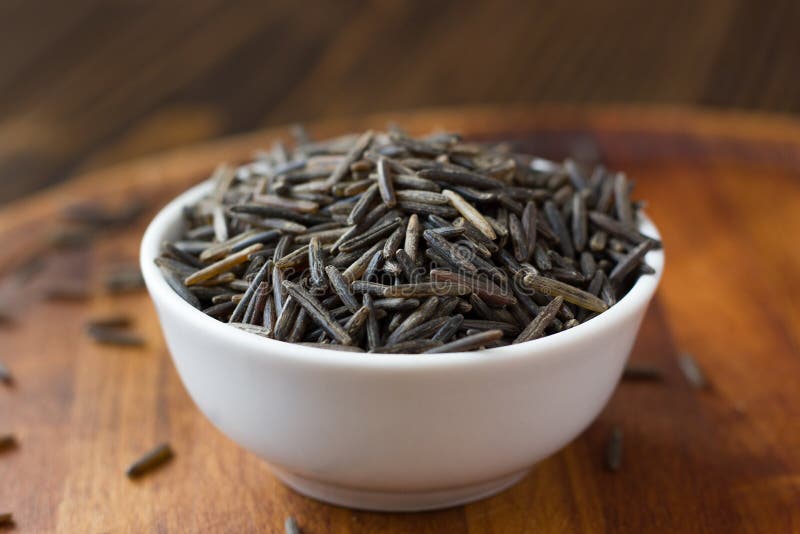 Black Wild Rice in Ceramic Bowl Over Wooden Board Stock Photo - Image ...