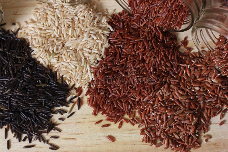 Black Wild Rice on Wooden Table with Brown Rice and Himalayan Red Rice ...
