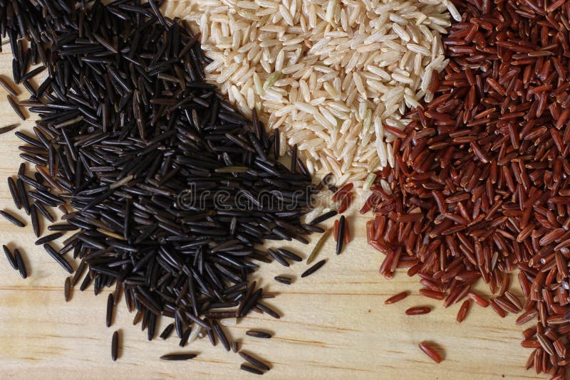 Black Wild Rice on Wooden Table with Brown Rice and Himalayan Red Rice ...