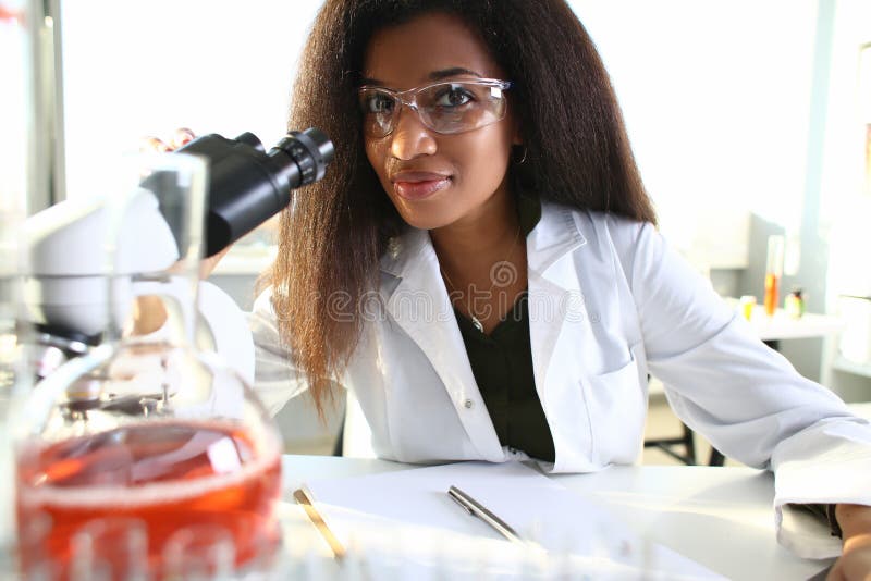 Black Woman Scientist in Goggles, Conducts Study Using Microscope Stock ...
