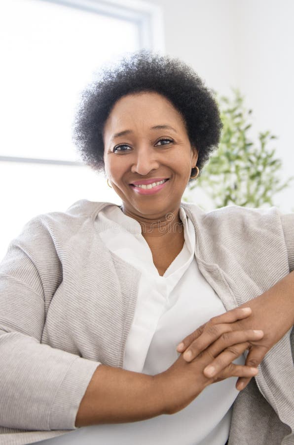 Black Woman Sitting on Sofa at Home with Beautiful Smile Stock Photo ...