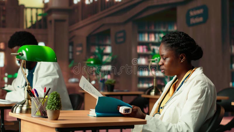 Black Woman Student in Med School Using Oximeter and Reading about the ...
