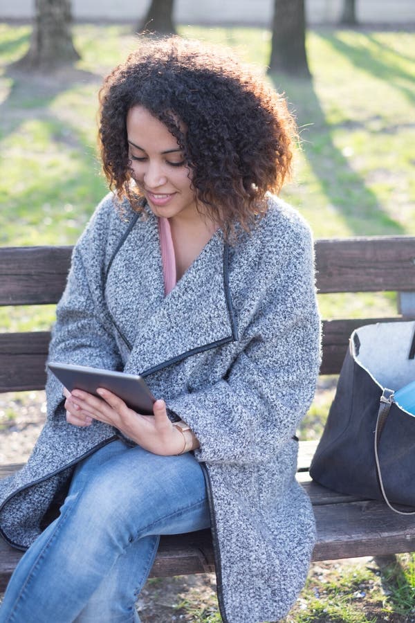 Black Woman Using App on Tablet Seated Bench Stock Photo - Image of ...