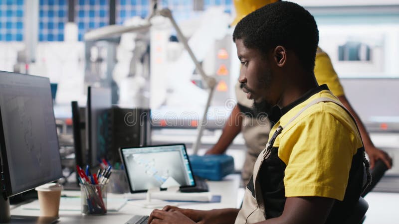 Black Worker Programming Robotic Assembly Line in Solar Cell Factory ...