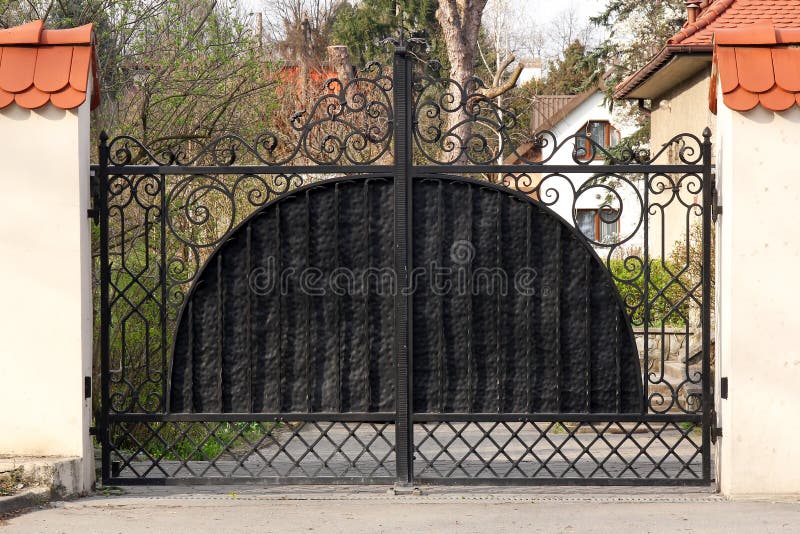 Black Wrought Gate To Property with Garden in the Background Stock ...