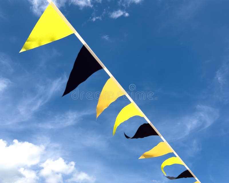 Black and Yellow Flags Against a Blue Sky. Holiday Stock Image - Image ...