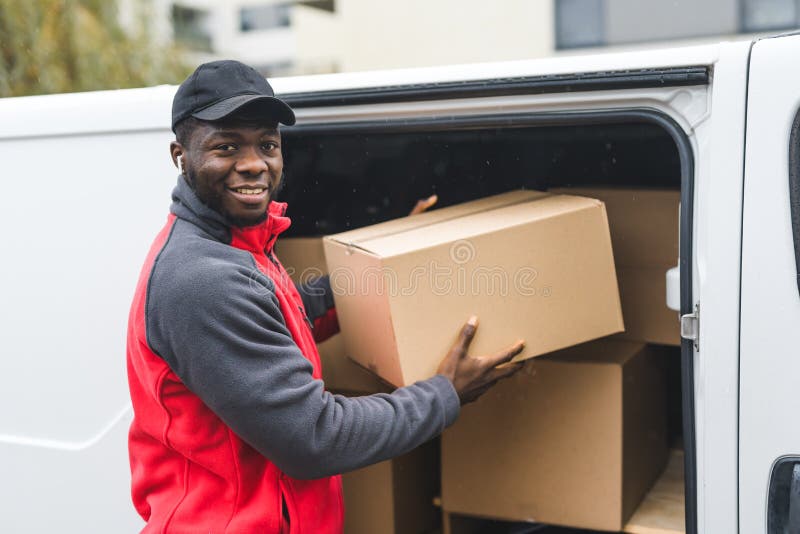 Black Young Adult Delivery Guy in Work Uniform and Black Cap Unloading ...