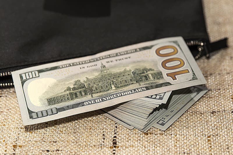 Black Zippered Wallet Full of US Hundred Dollar Bills Lying on Textile ...