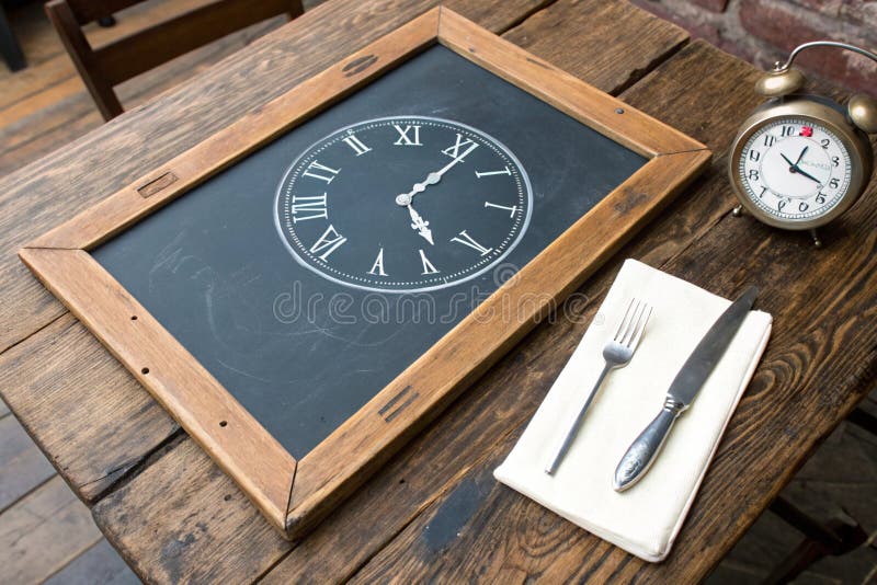 Blackboard with Clock and Cutlery on Wooden Dining Table Stock ...