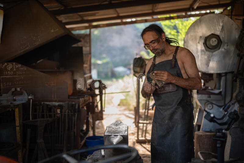 Blacksmith Adjusting His Hammer To Work in His Forge Shop Stock Photo ...