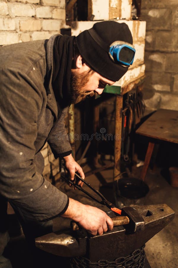 Blacksmith Forges a Hot Metal on the Anvil with a Hammer. Stock Image ...