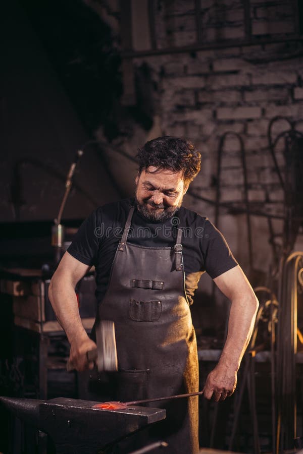 Blacksmith Forging Molten Metal on the Anvil in Smithy. Stock Image ...