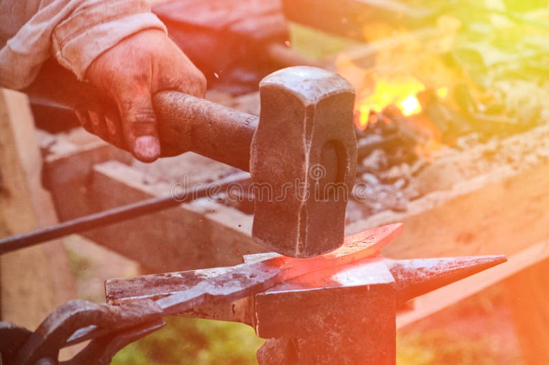 Blacksmith Hammer Hits the Hot Metal. Forging of Iron Objects in a ...