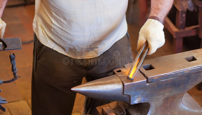 Blacksmith Hammering a Glowing Hot Metal Rod on an Anvil in a ...