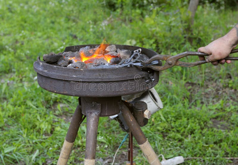 Blacksmith Hand Holding Forceps with a Metal Billet in a Burning Forge ...