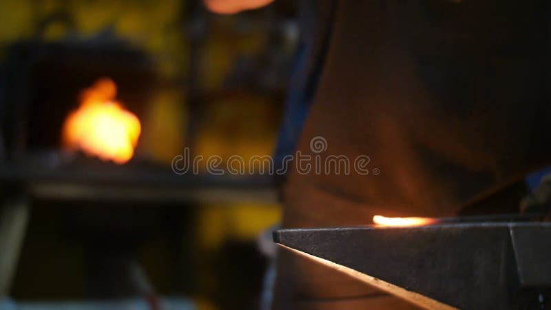 Blacksmith Hitting Hot Metal with a Hammer on an Anvil Inside His ...