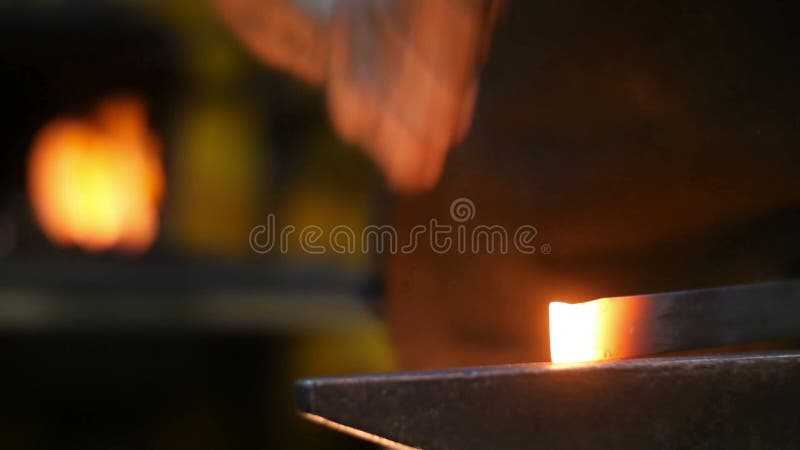 Blacksmith Hitting Hot Metal with a Hammer on an Anvil Inside His ...