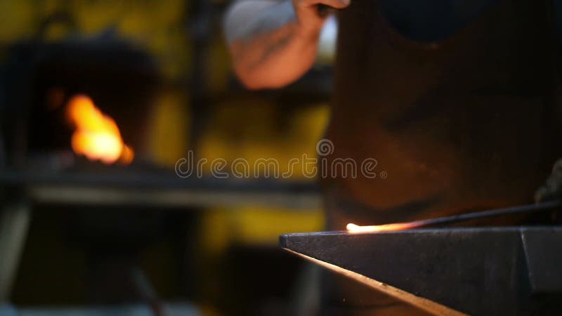 Blacksmith Hitting Hot Metal with a Hammer on an Anvil Inside His ...