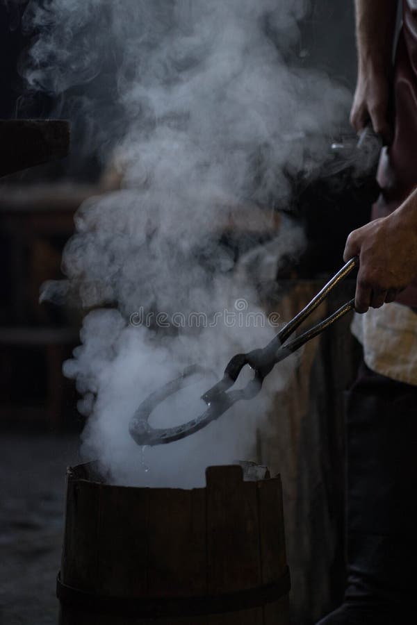 Blacksmith Holding Iron Work in Forge Stock Photo - Image of hammer ...