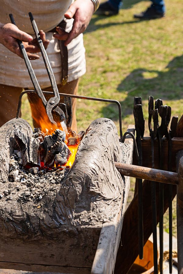 The Blacksmith Holds the Billet Over Hot Coals in a Clay Oven ...