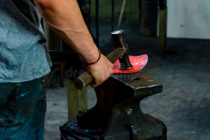 The Blacksmith Manually Forging the Molten Metal on the Anvil Stock ...