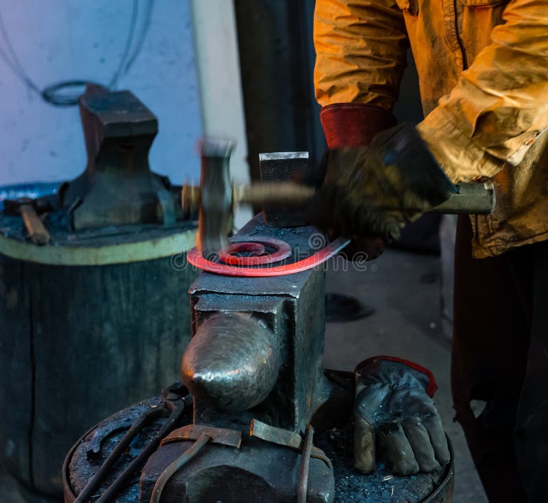 The Blacksmith Manually Forging the Molten Metal on the Anvil Stock ...