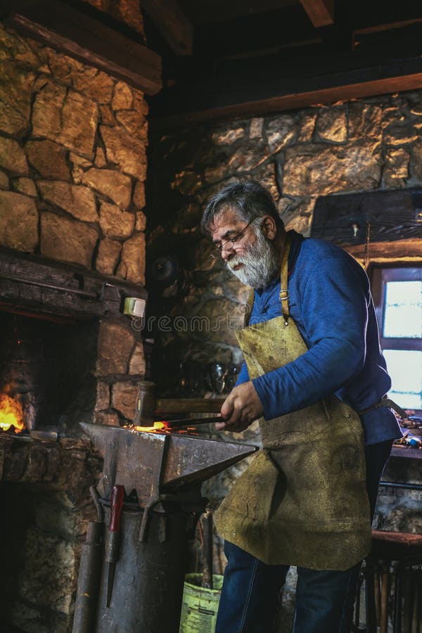 Blacksmith Manually Forging the Molten Metal on the Anvil in Smithy ...