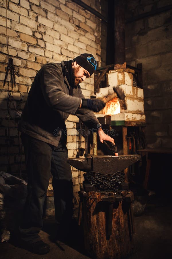 The Blacksmith Manually Forging the Red-hot Metal on the Anvil. Stock ...
