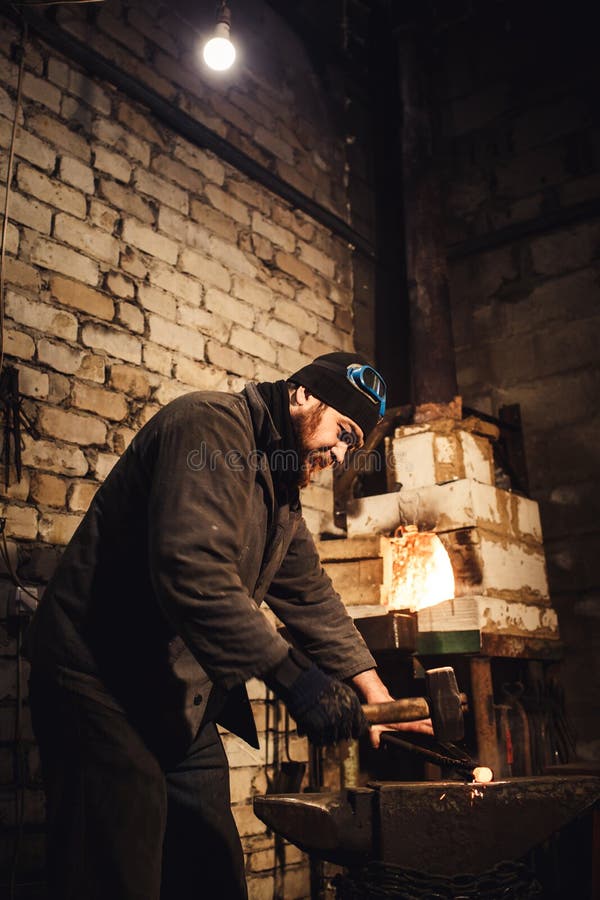 The Blacksmith Manually Forging the Red-hot Metal on the Anvil. Stock ...