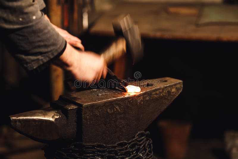 The Blacksmith Manually Forging the Red-hot Metal on the Anvil in ...